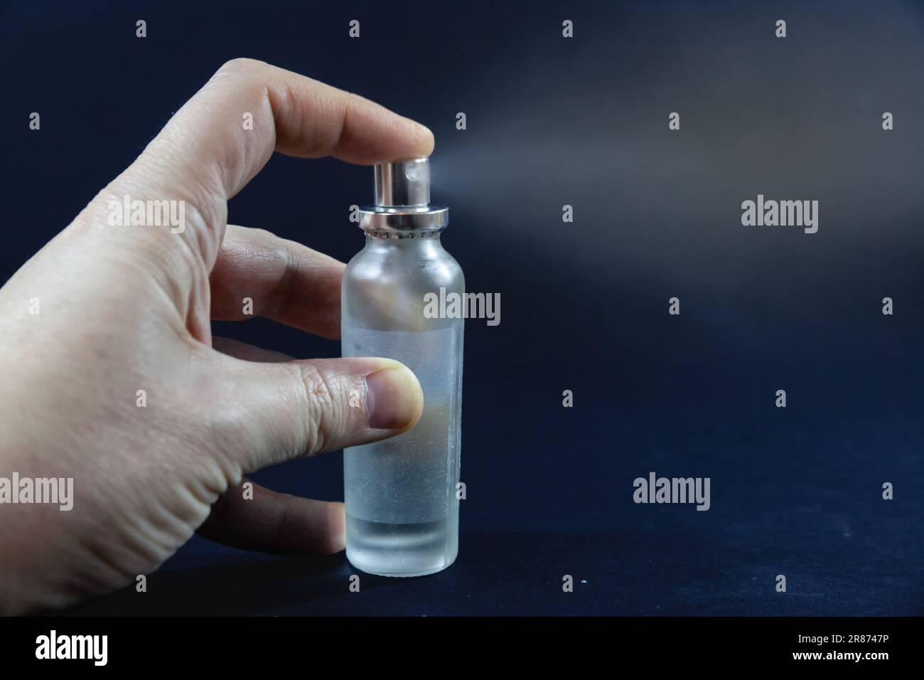 Picture of a small perfume bottle spraying fragrance, being pushed by ...