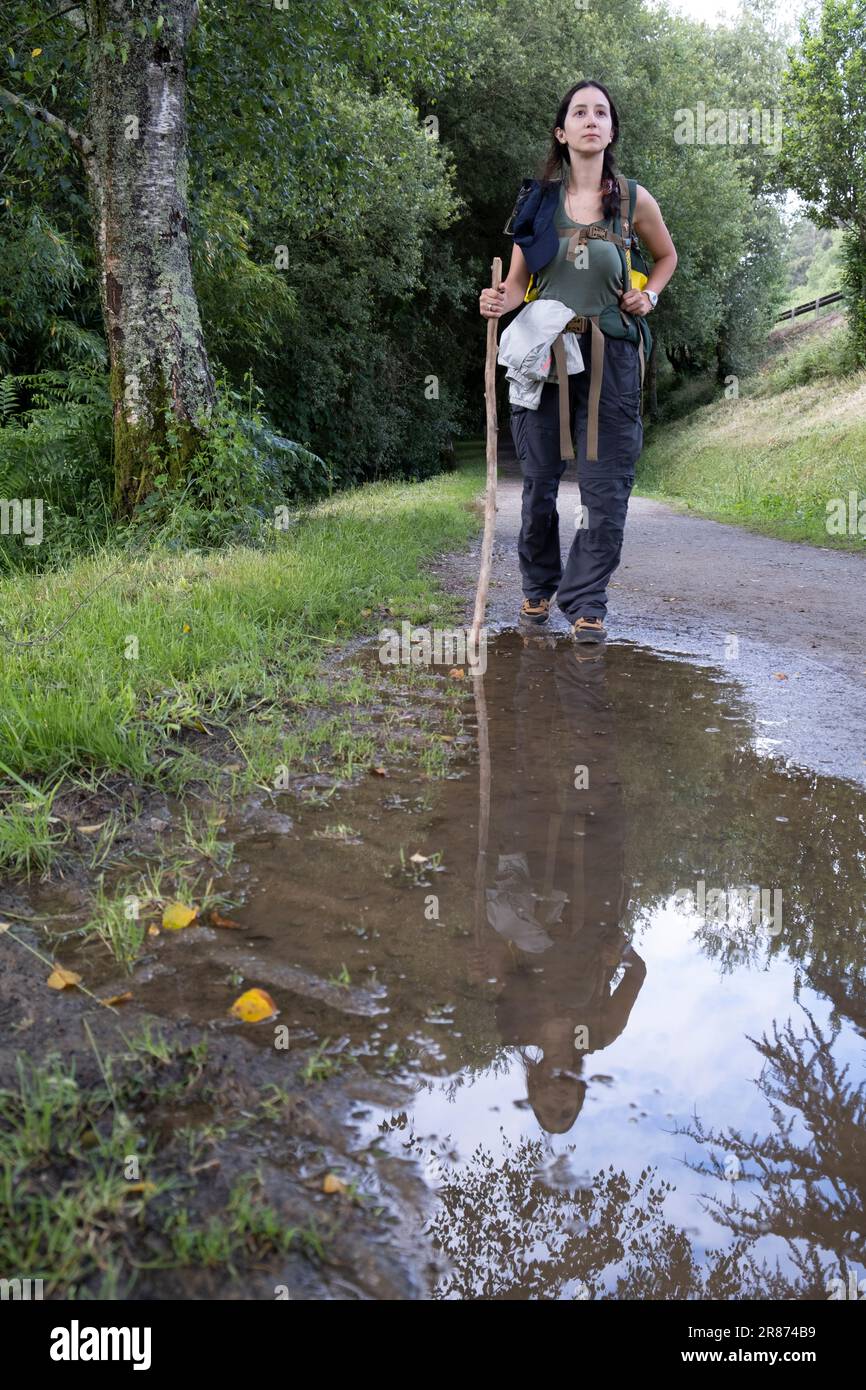 Young woman pilgrim walking on a trail of the way of saint james ...