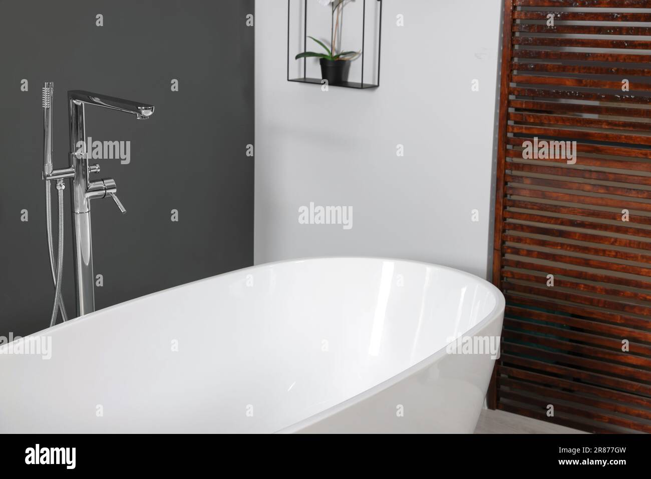 Stylish ceramic tub and modern tab in bathroom Stock Photo - Alamy