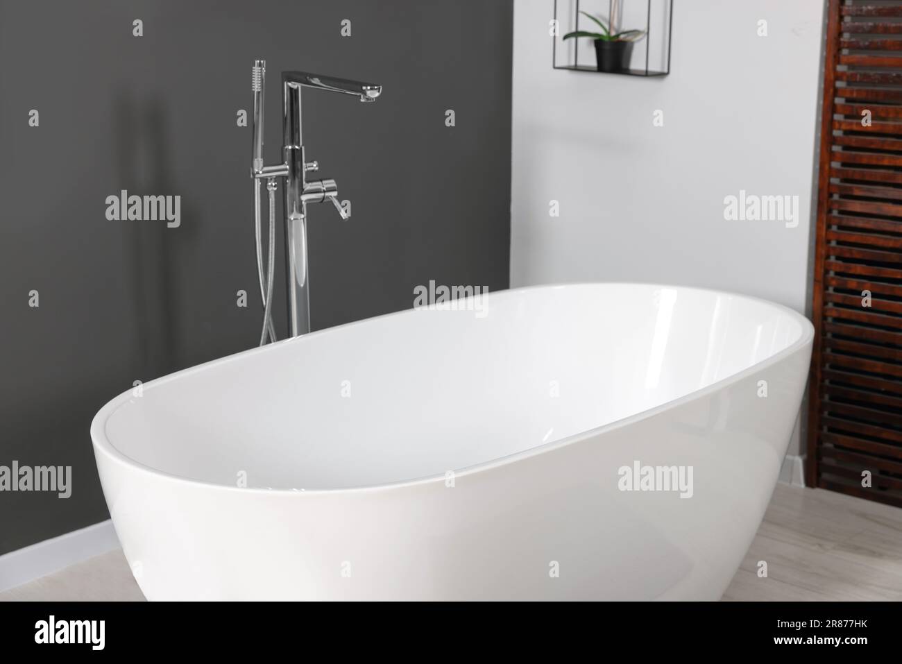 Stylish ceramic tub and modern tab in bathroom Stock Photo - Alamy
