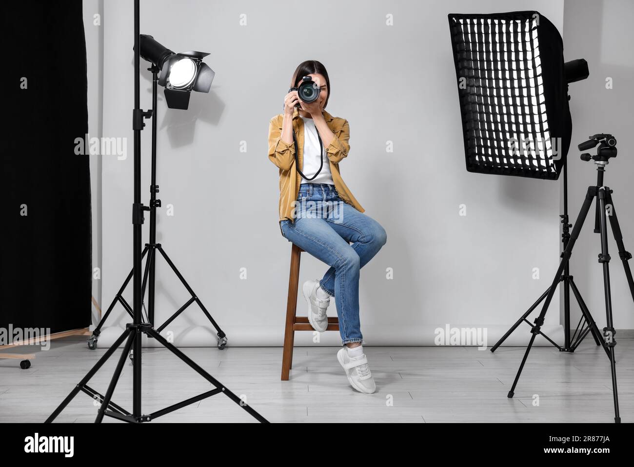 Professional photographer with camera in modern photo studio Stock ...