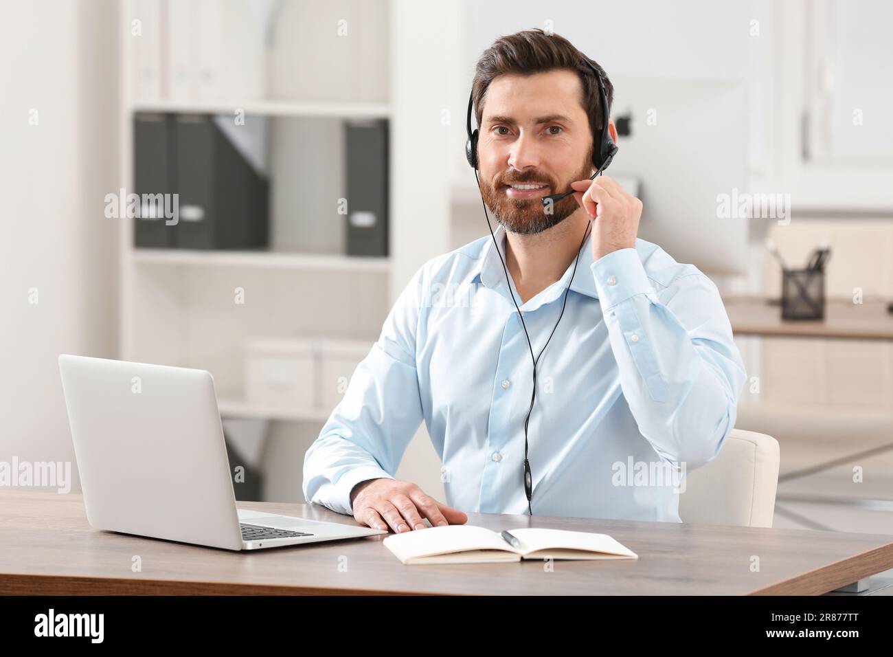 Hotline operator with headset working in office Stock Photo - Alamy