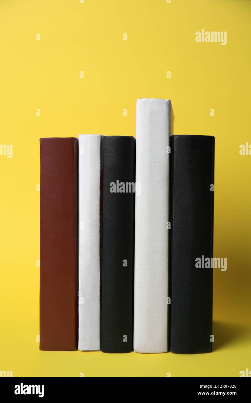 Collection of hardcover books on yellow background Stock Photo - Alamy