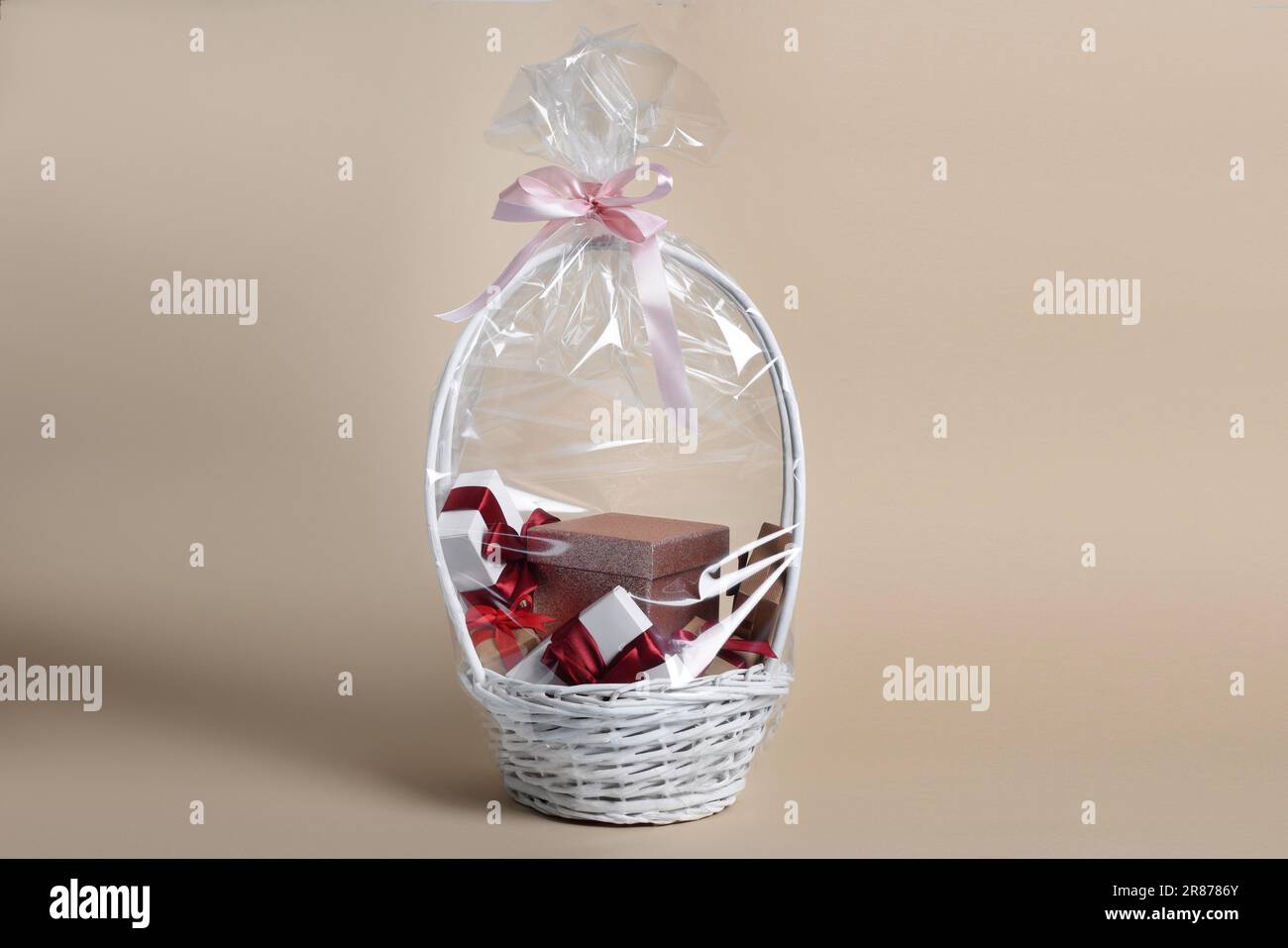 Wicker basket full of gift boxes on beige background Stock Photo - Alamy