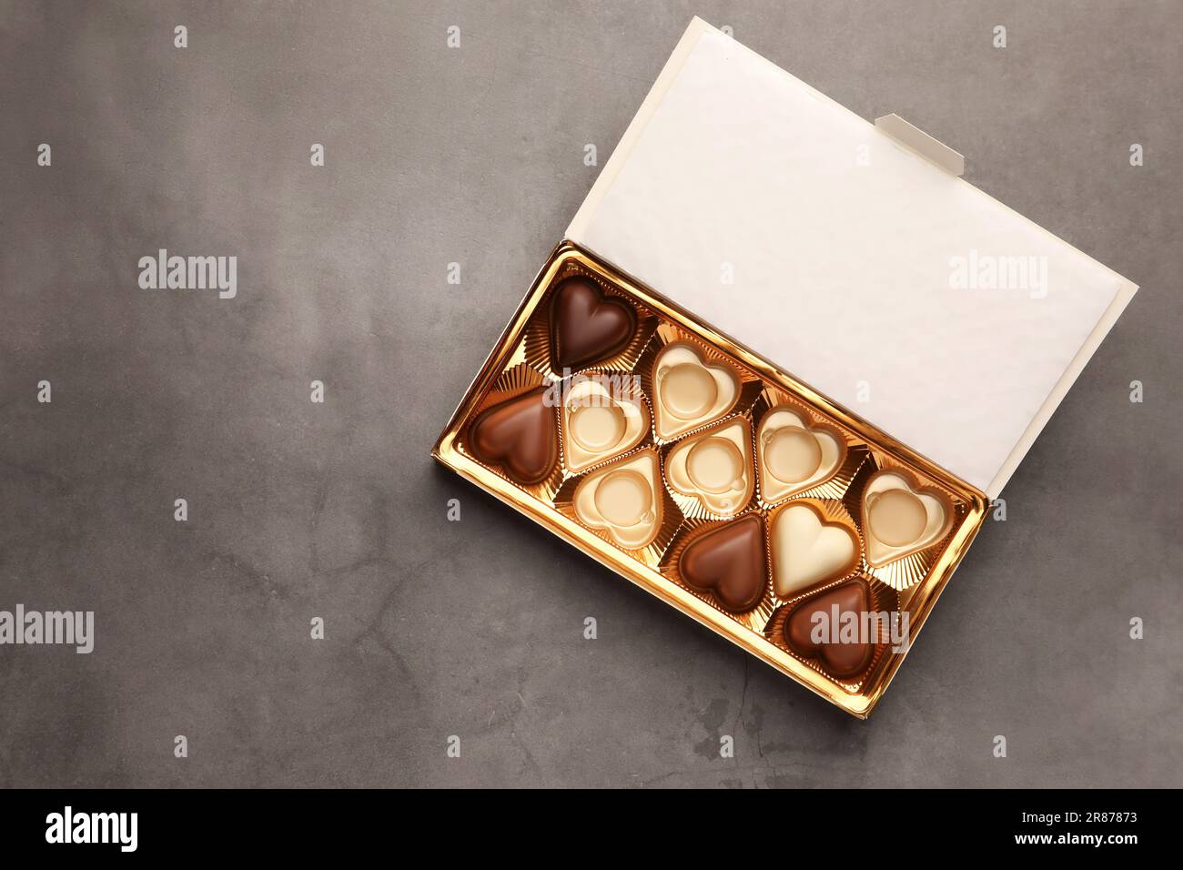 Partially empty box of chocolate candies on grey background, top view ...