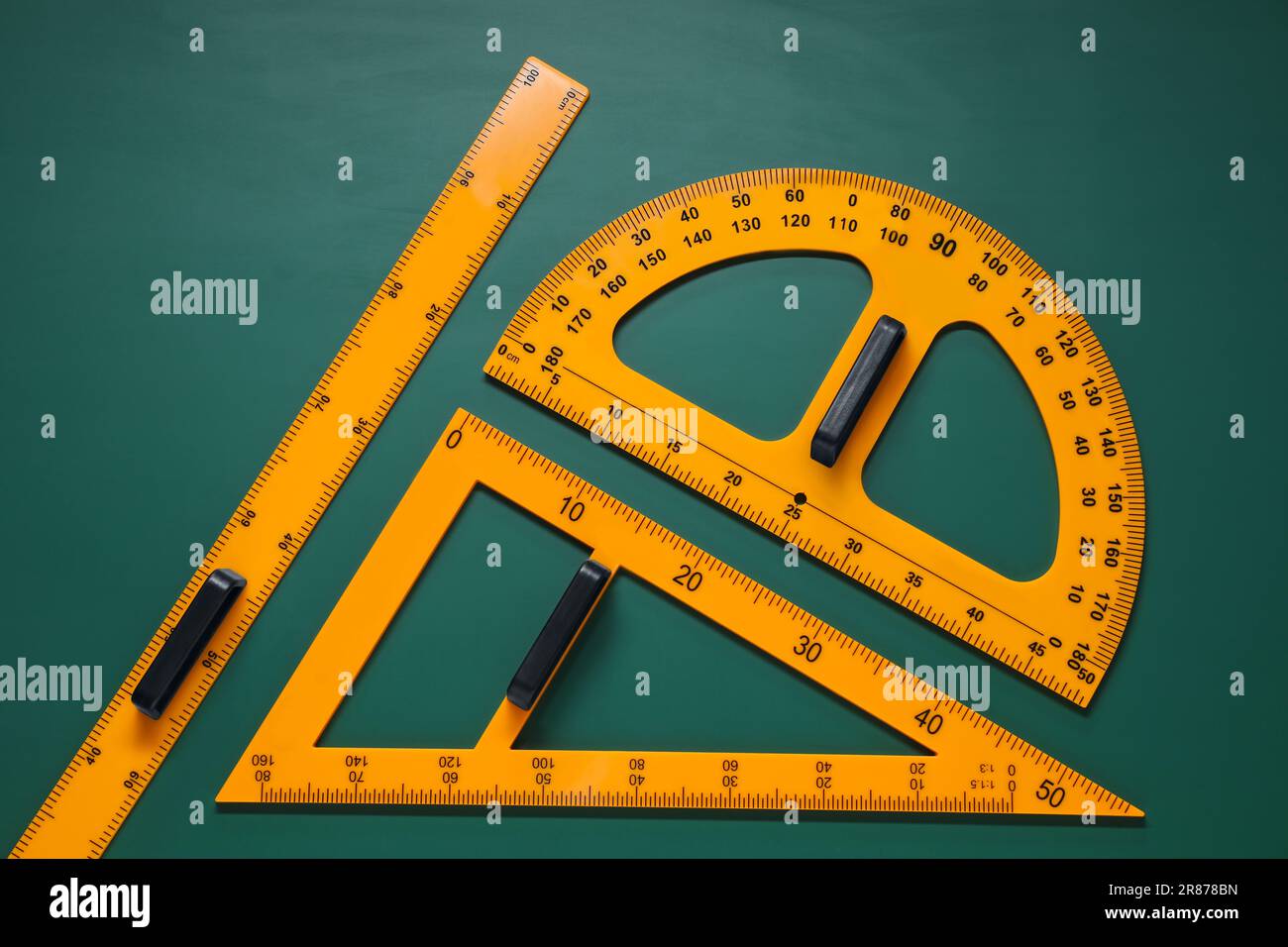 Protractor, triangle and ruler on green chalkboard, flat lay Stock ...