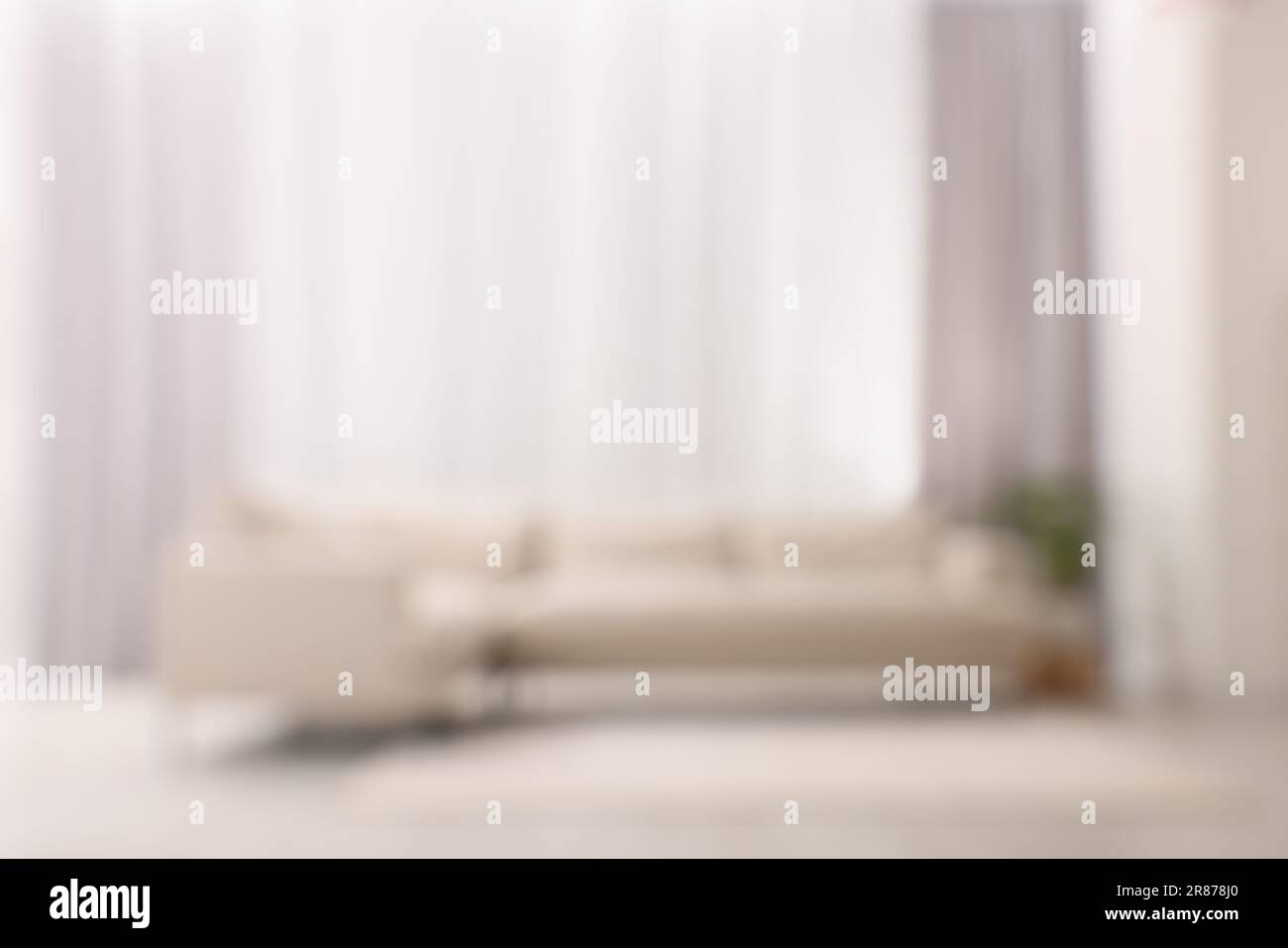 Blurred view of comfortable sofa and window with beautiful curtains in ...