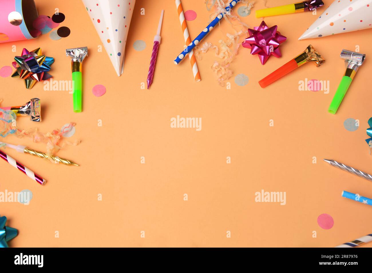 Party blowers, streamers and other festive decor on coral background ...