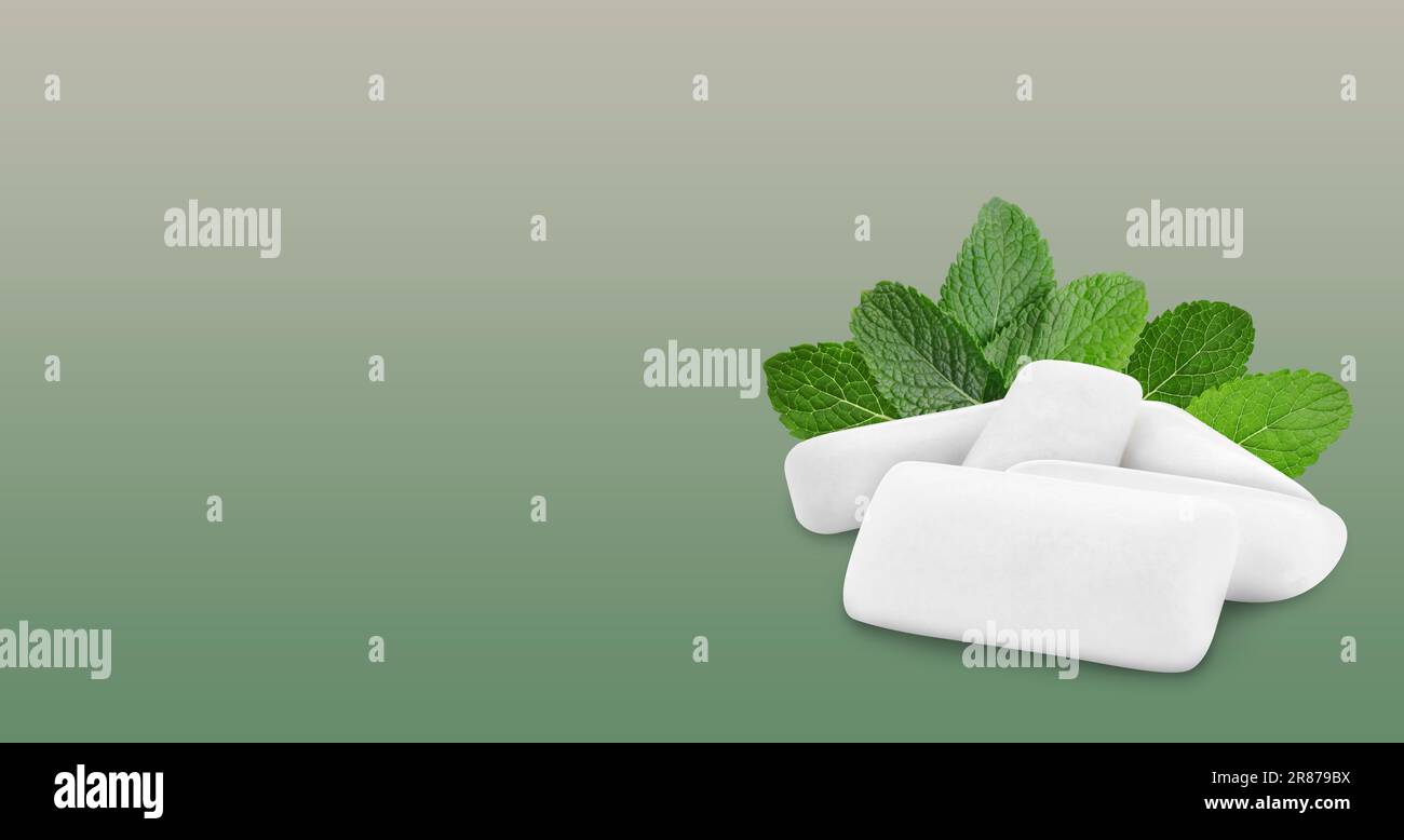 Menthol chewing gum pillows and mint leaves on dark green gradient ...