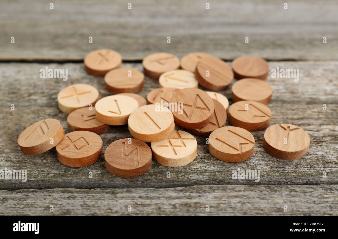 Pile of runes with different symbols on wooden table Stock Photo - Alamy