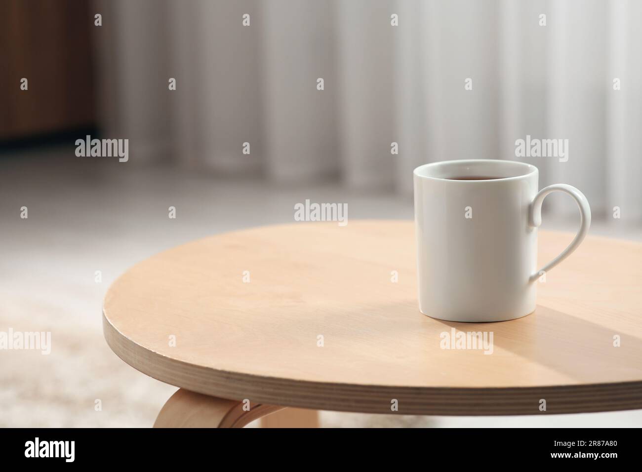White mug on wooden table indoors. Mockup for design Stock Photo - Alamy