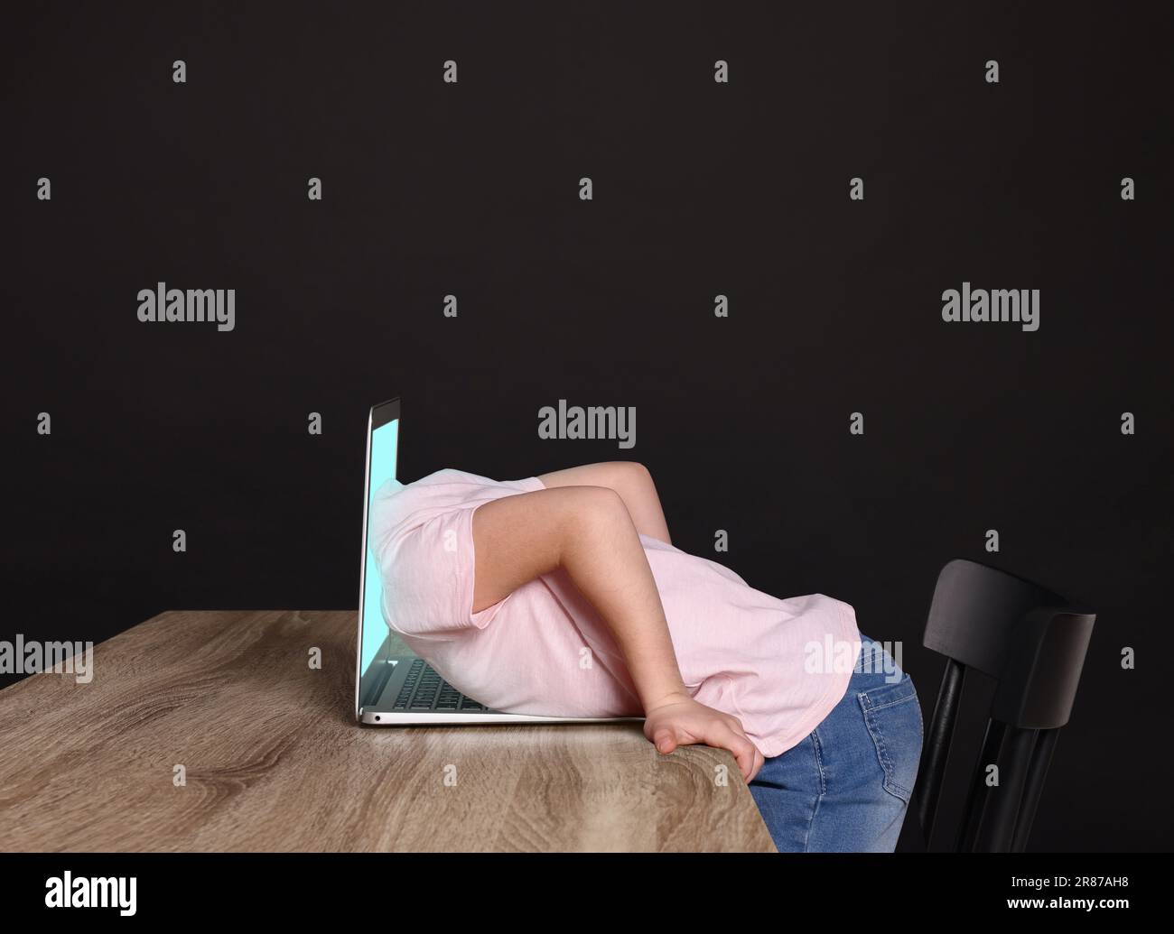 Internet addiction. Little girl getting into laptop against black ...