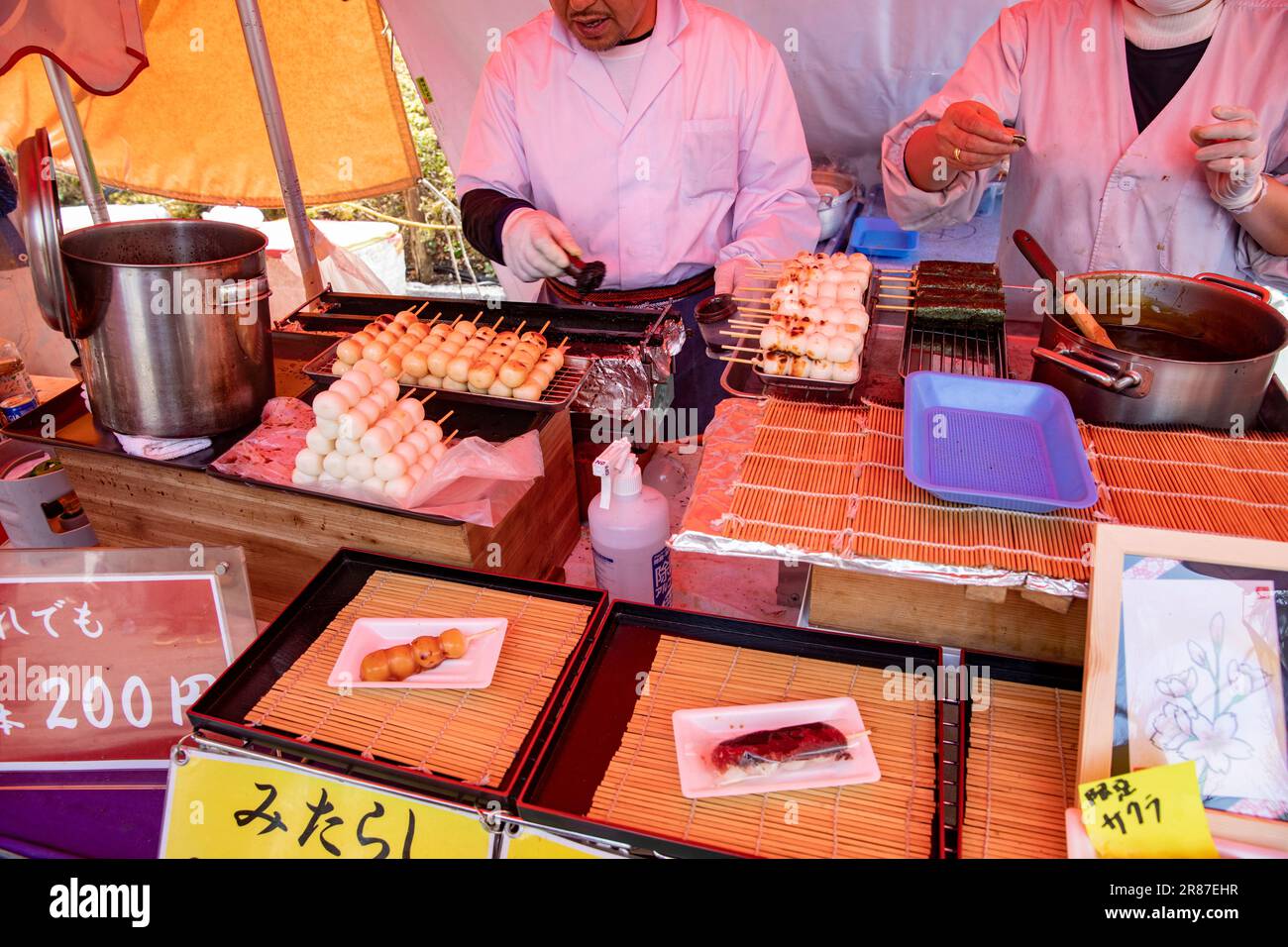 Japanese food stall and chef cooking and serving octopus balls Takoyaki ...