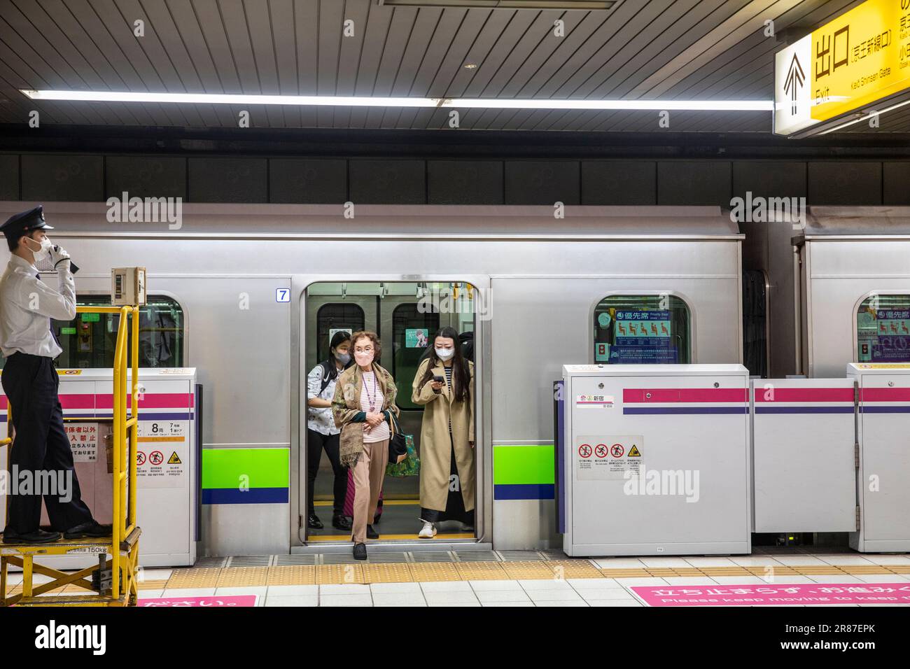 Tokyo metro railway network employee train guard at a station as ...