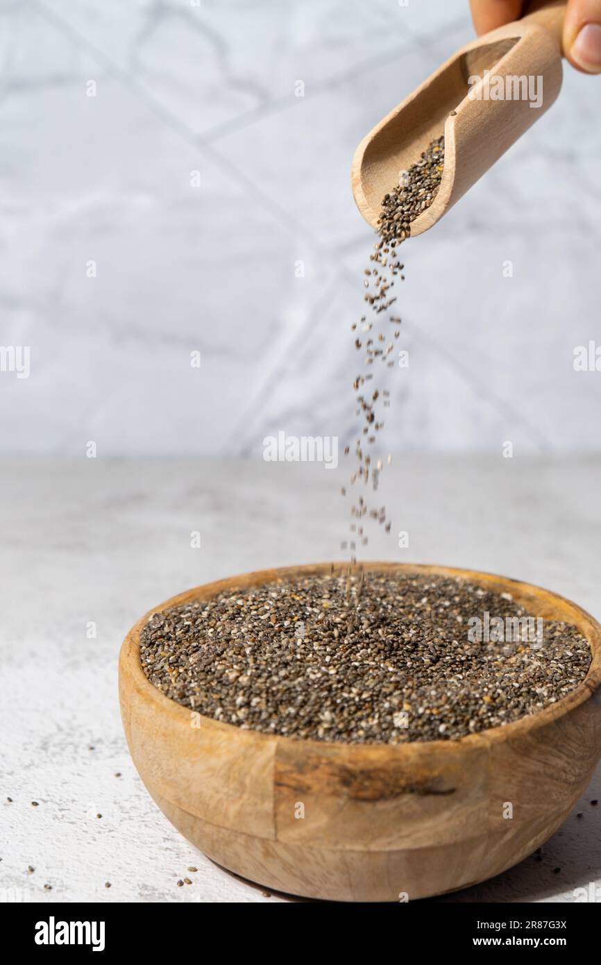 Chia seeds fall in wooden bowl. Healthy superfood rich in Omega 3 fatty ...
