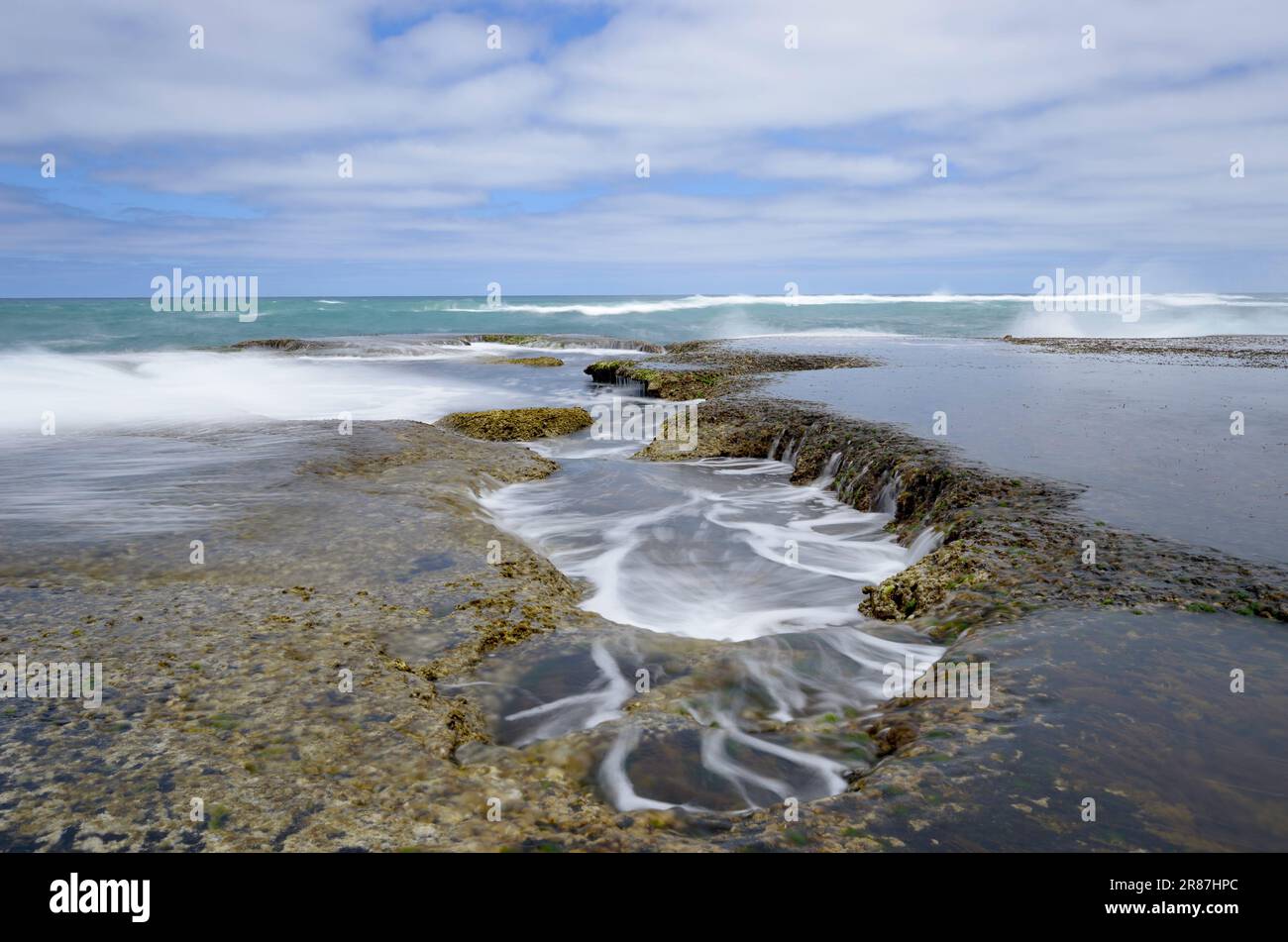 Tidal rock pools exposed at low tide creating little mini waterfalls ...