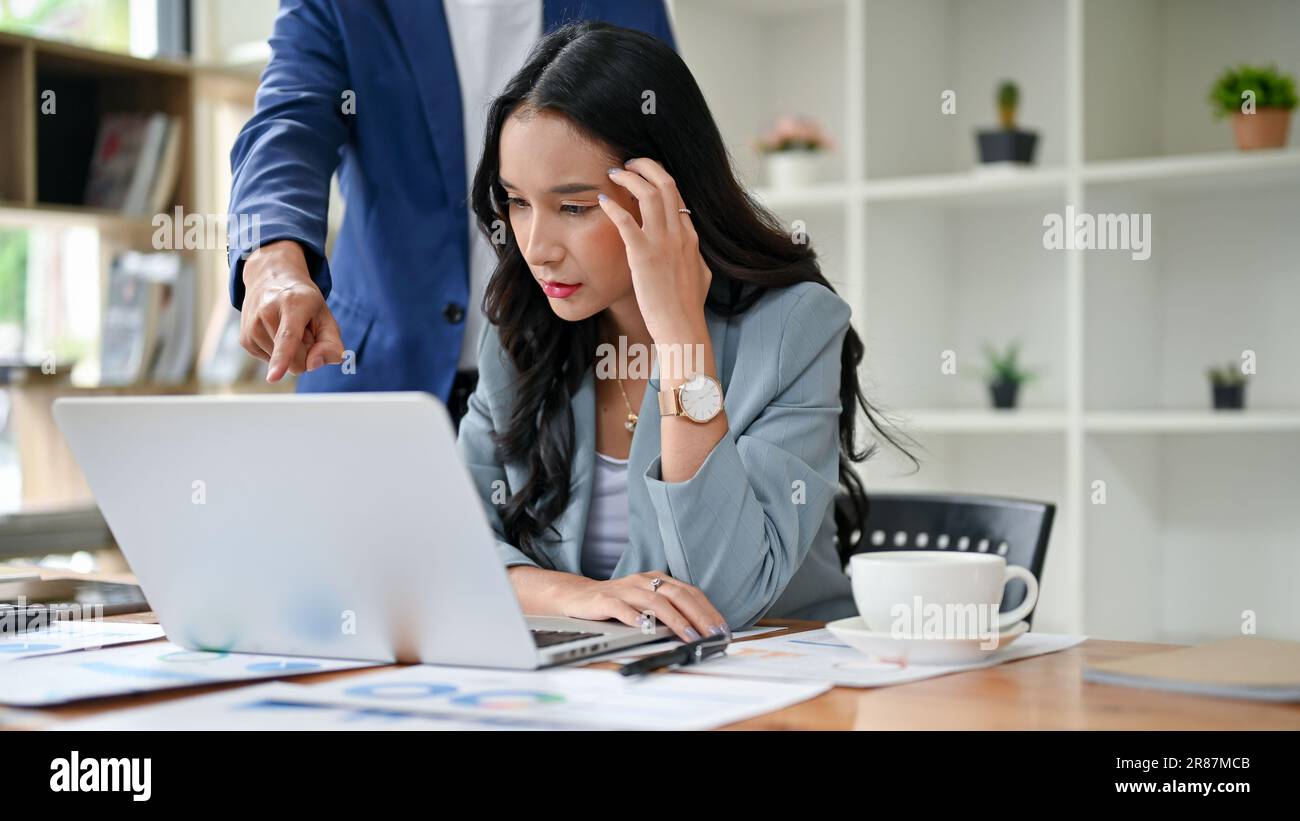 A stressed millennial Asian female office worker is being complained ...