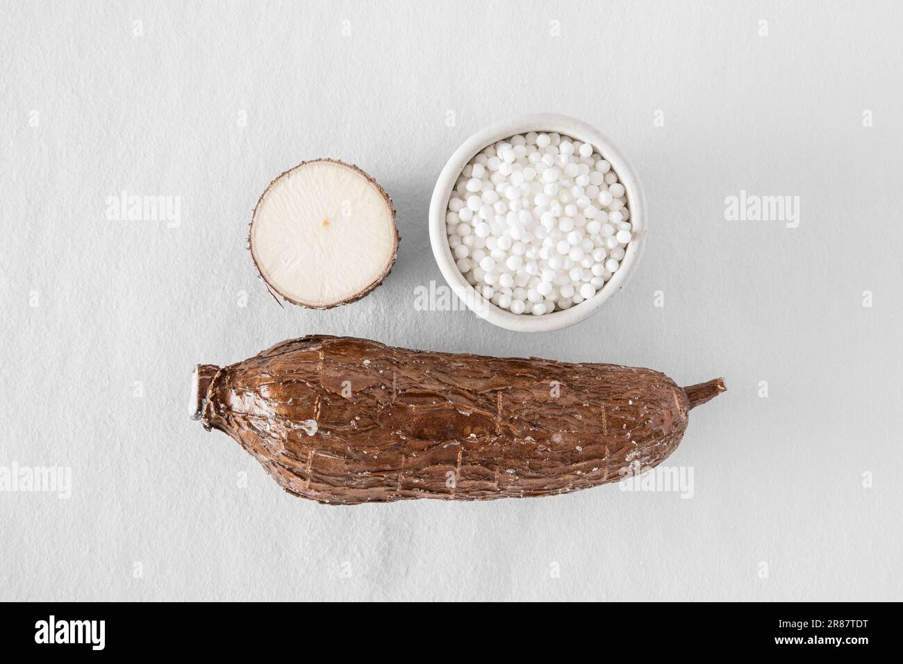 Close-up of a cassava root on a white background with tapioca pearls ...