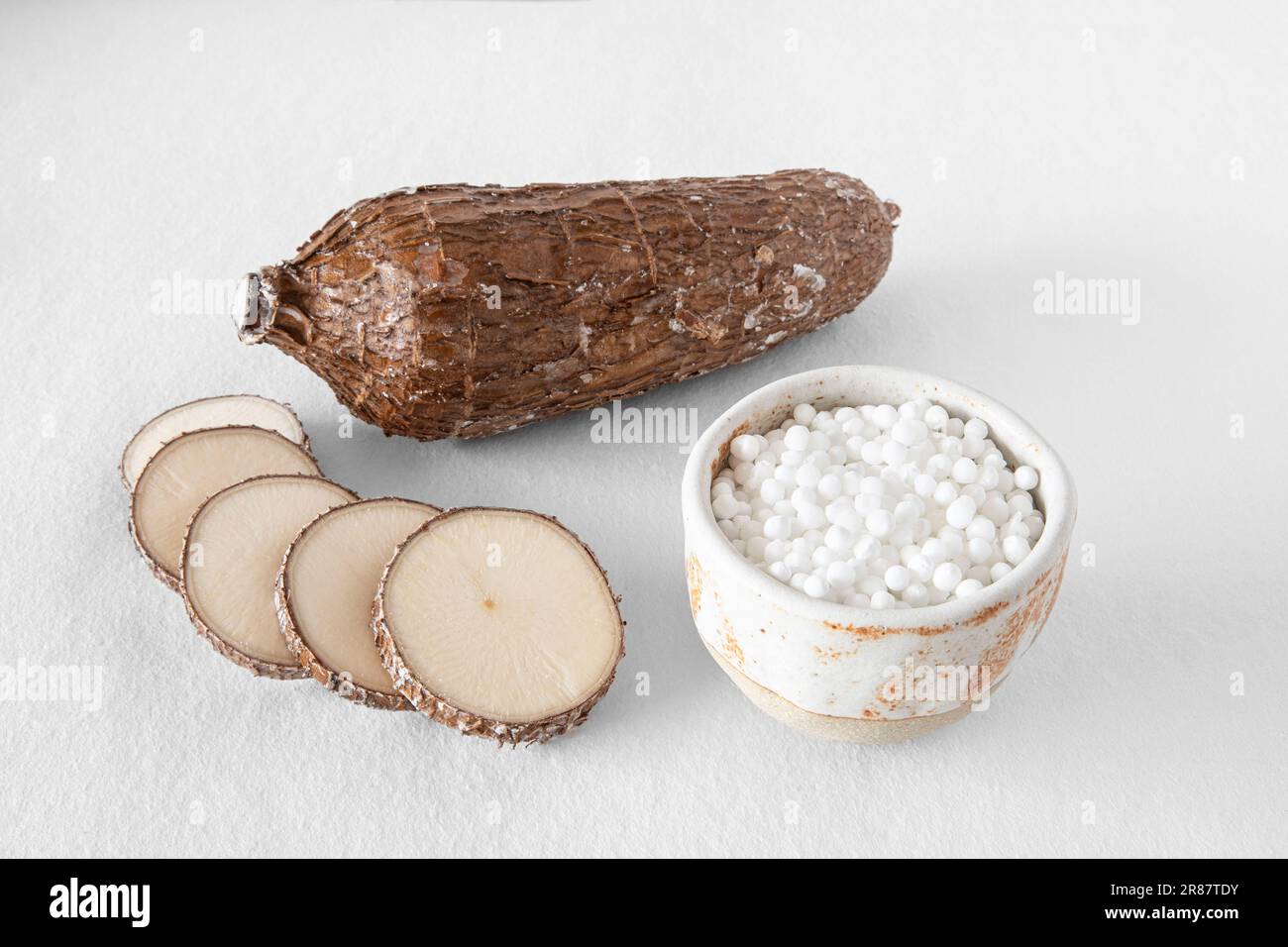 Close-up of a cassava root on a white background with tapioca pearls ...