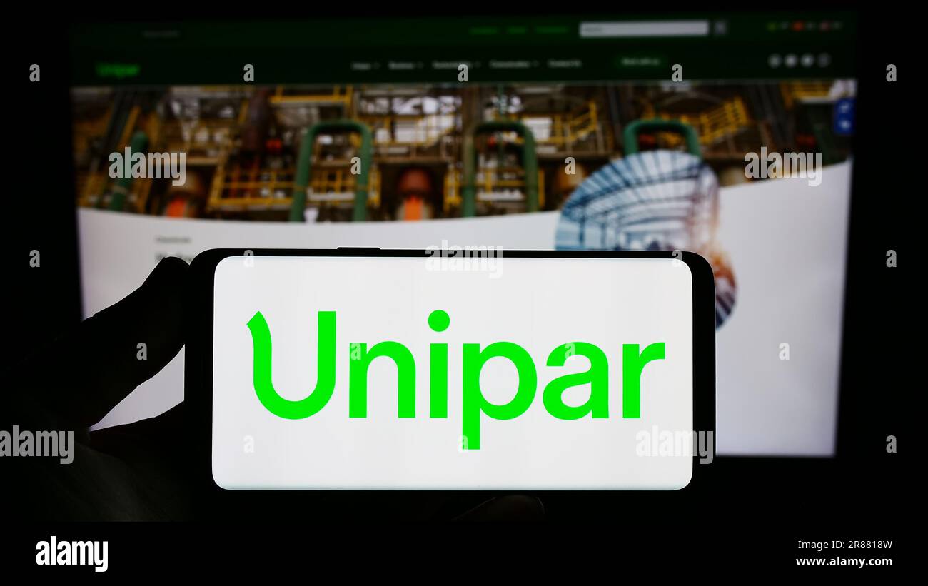 Person holding smartphone with logo of Brazilian company Unipar ...