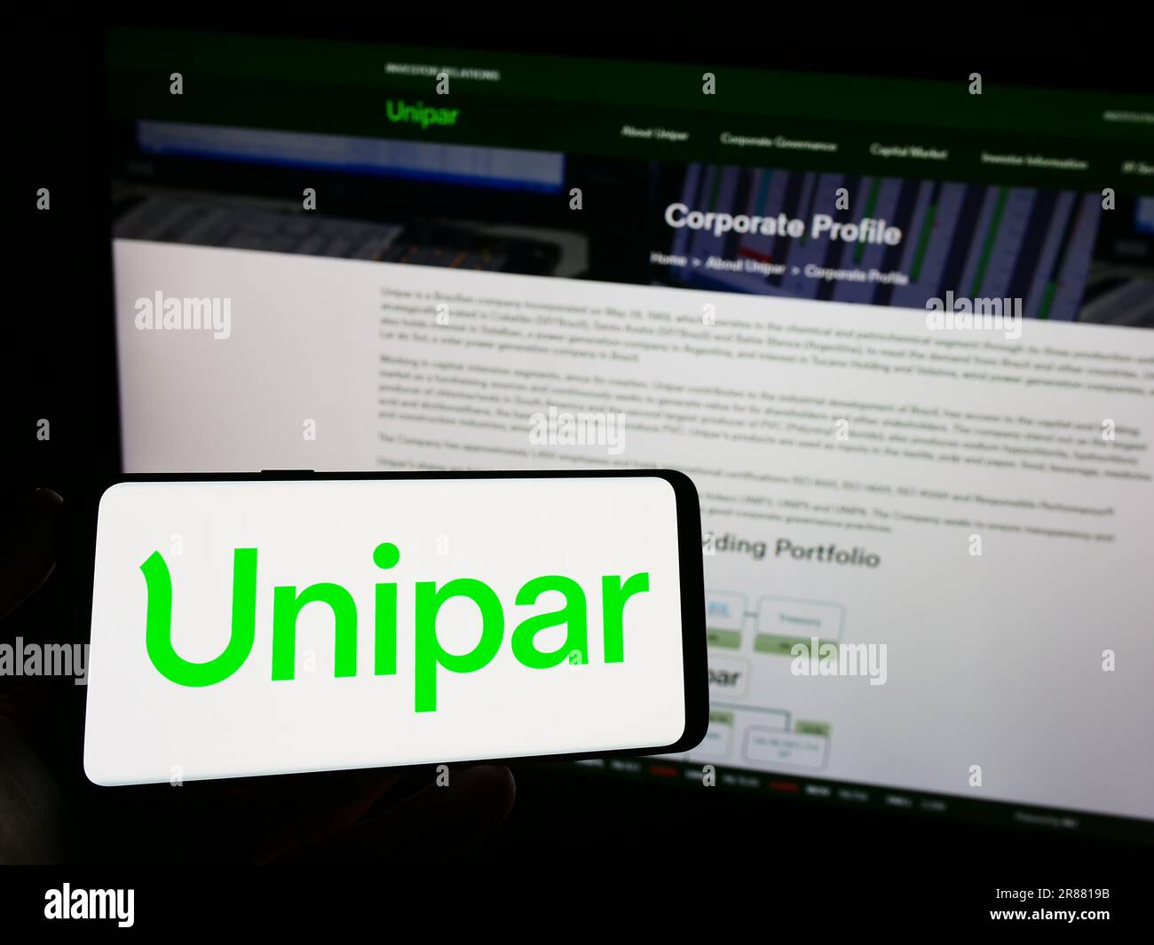 Person holding mobile phone with logo of Brazilian company Unipar ...
