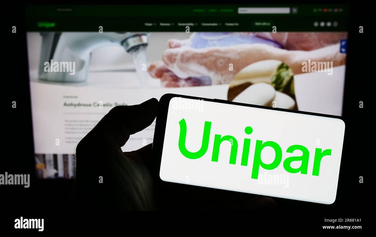 Person holding cellphone with logo of Brazilian company Unipar ...