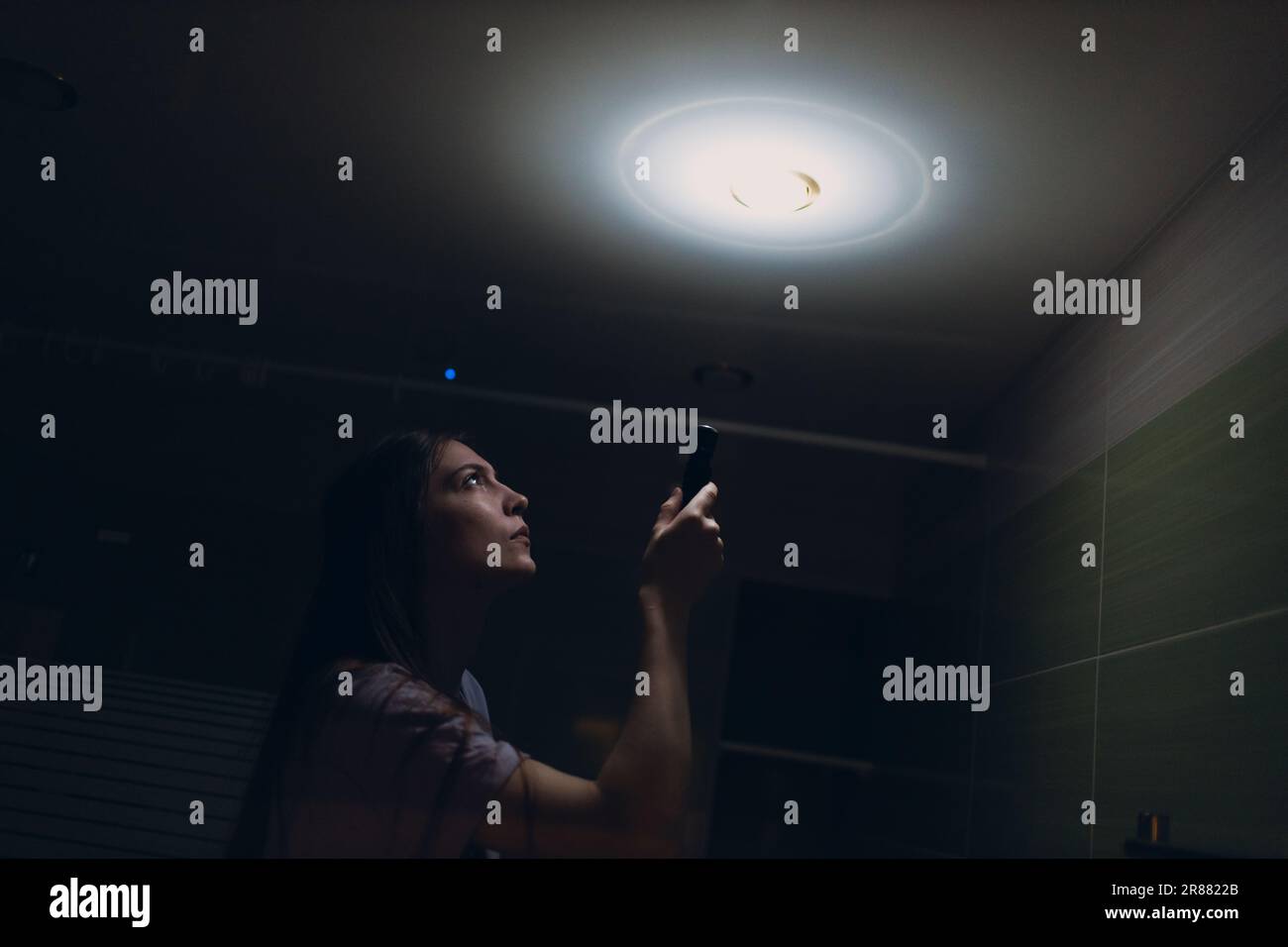Woman young holding hand flashlight in darkness. Disconnecting home ...