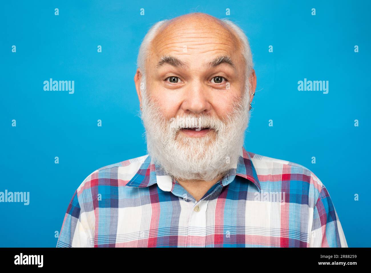Mature surprised man with grey beard on studio background. Portrait of ...