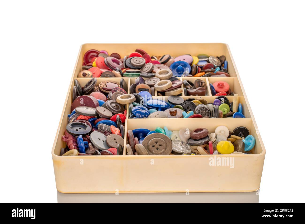 Many buttons in plastic container, macro isolated on white background ...