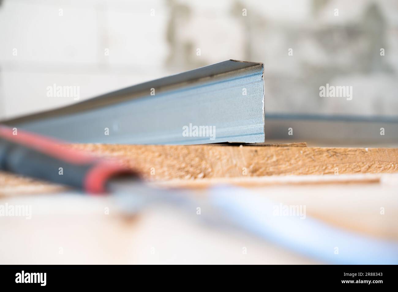 Cut off thin metal U profile from stainless steel close-up on a blurred ...