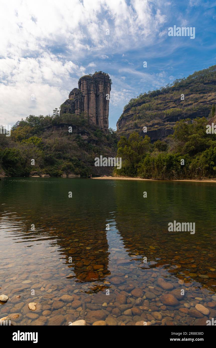 A rock cliff lining the nine bend river or Jiuxi in Wuyishan or Mount ...