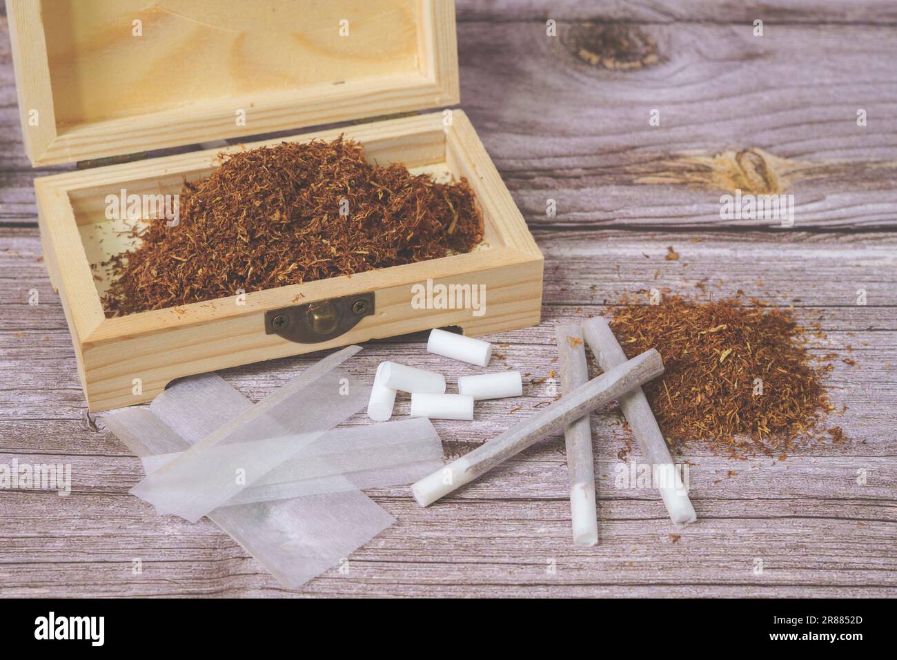 Wooden box with rolling tobacco, rolled cigarettes, cigarette papers ...