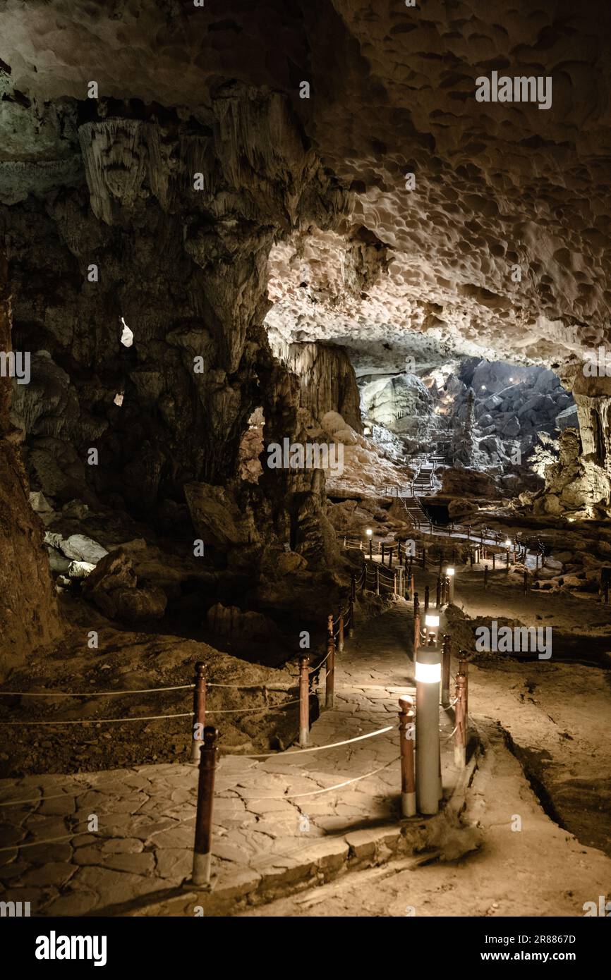 A dark cave with a winding pathway leading to the entrance, illuminated ...