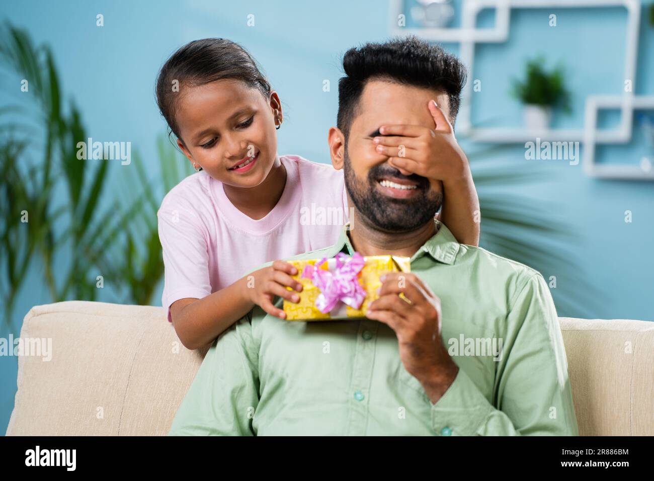 focus on kid, Happy excited indian girl kid giving gift to father by ...