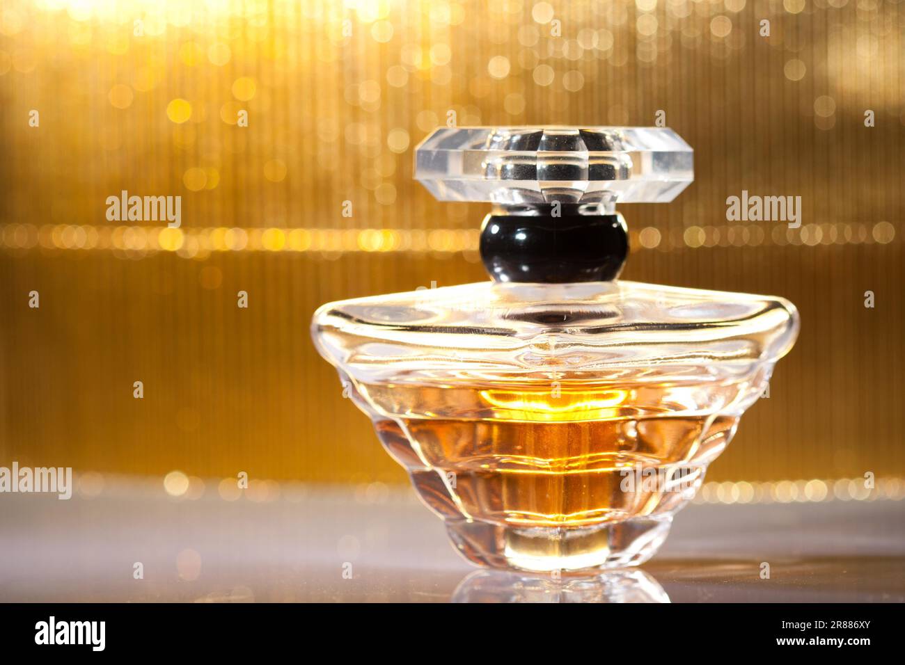 Bottle of perfume on abstract gold background Stock Photo - Alamy