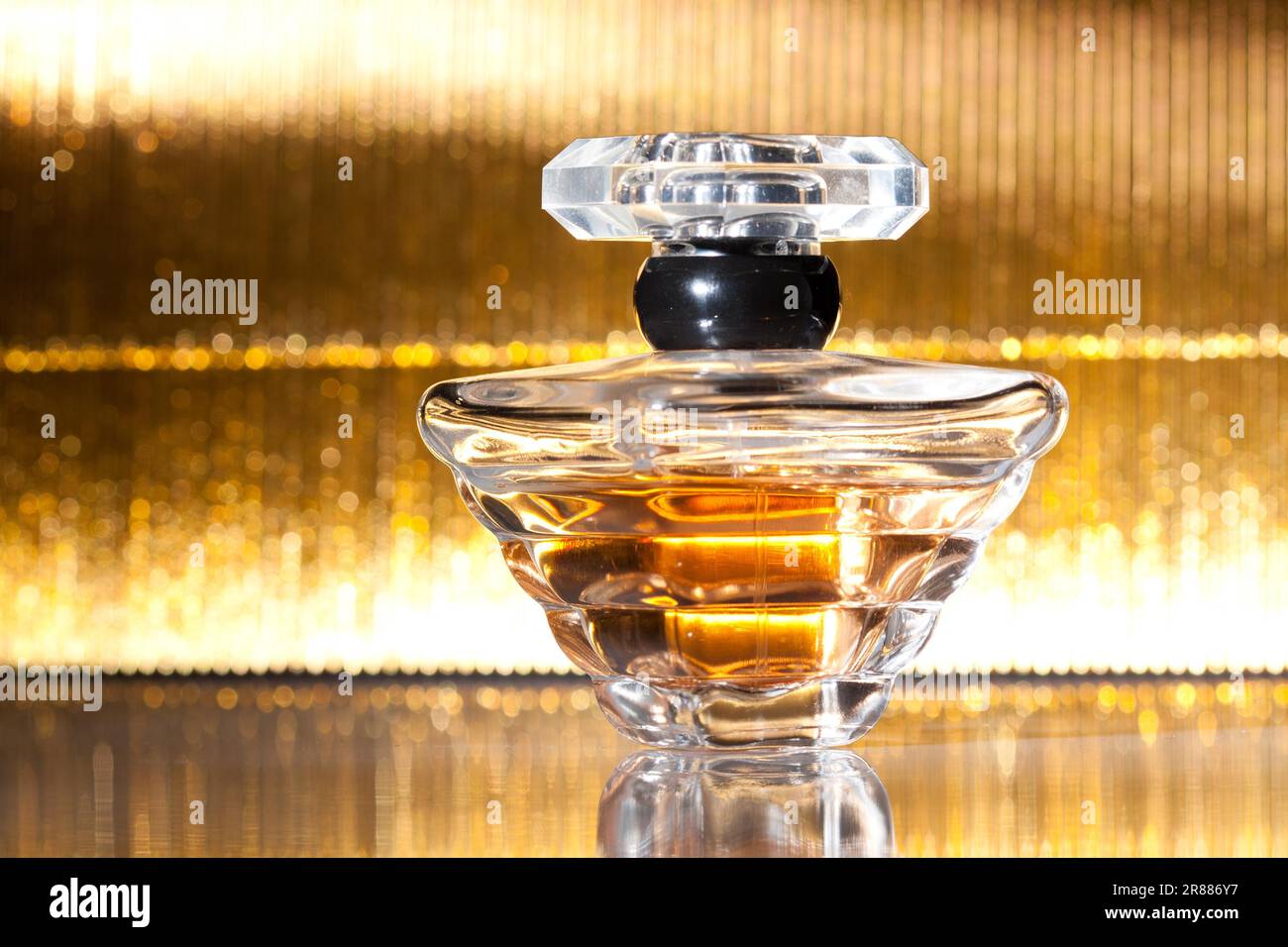 Bottle of perfume on shiny gold background Stock Photo - Alamy