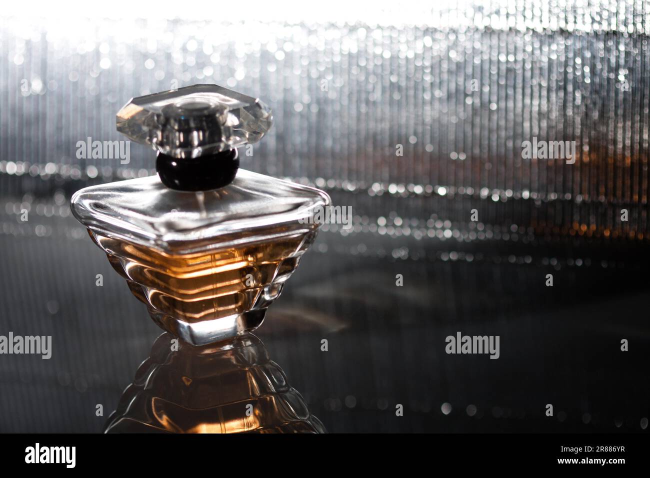 Bottle of perfume on shiny silver background Stock Photo - Alamy