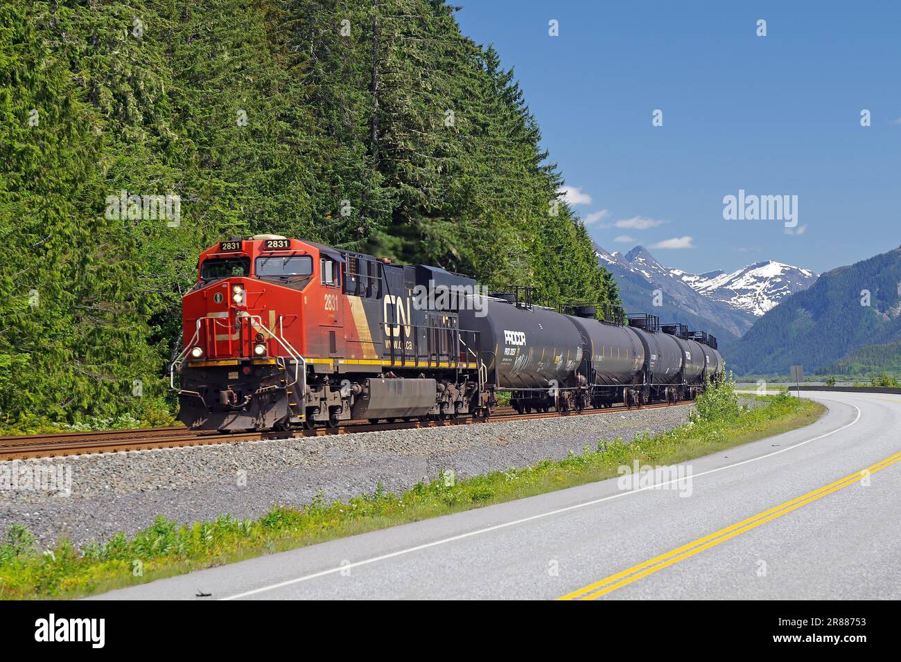 Locomotive and wagons of a long goods train next to a road, Prince ...