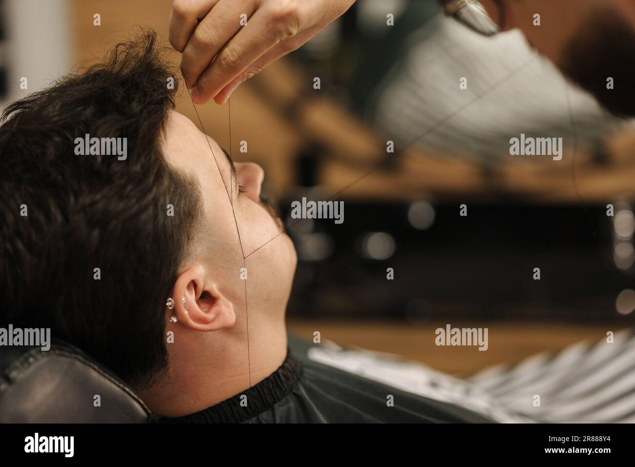 Process of threading procedure in barber shop. Professional barber ...
