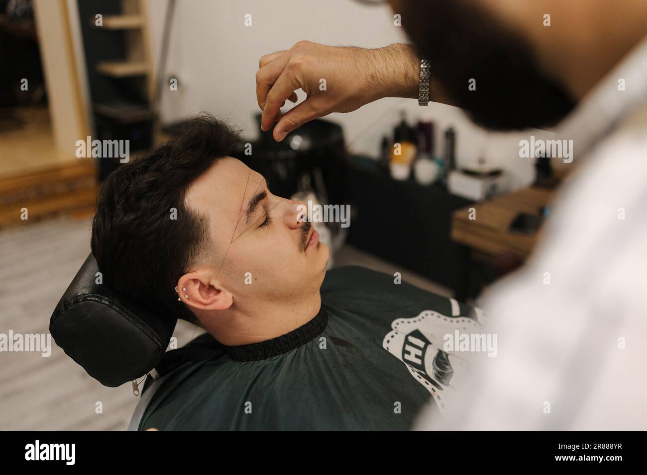Process of threading procedure in barber shop. Professional barber ...