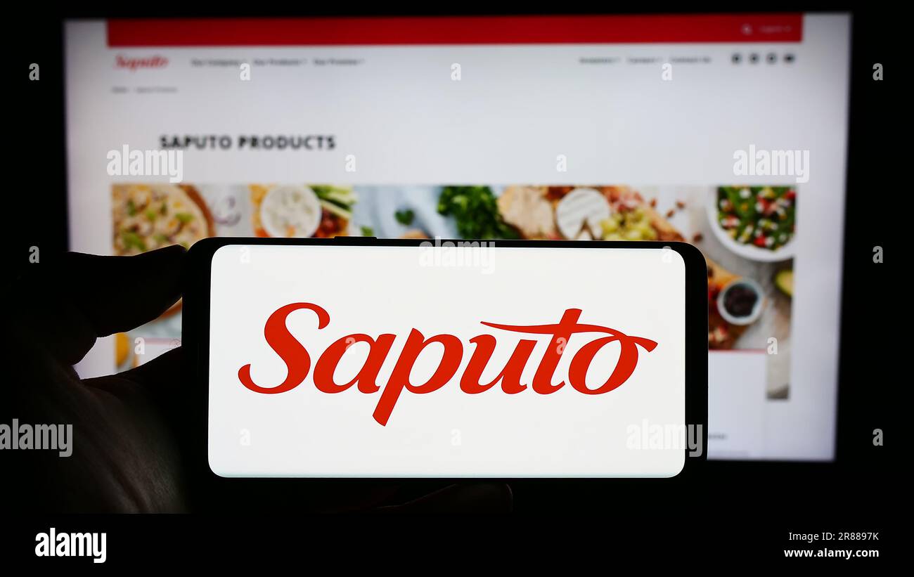Person holding smartphone with logo of Canadian dairy company Saputo ...
