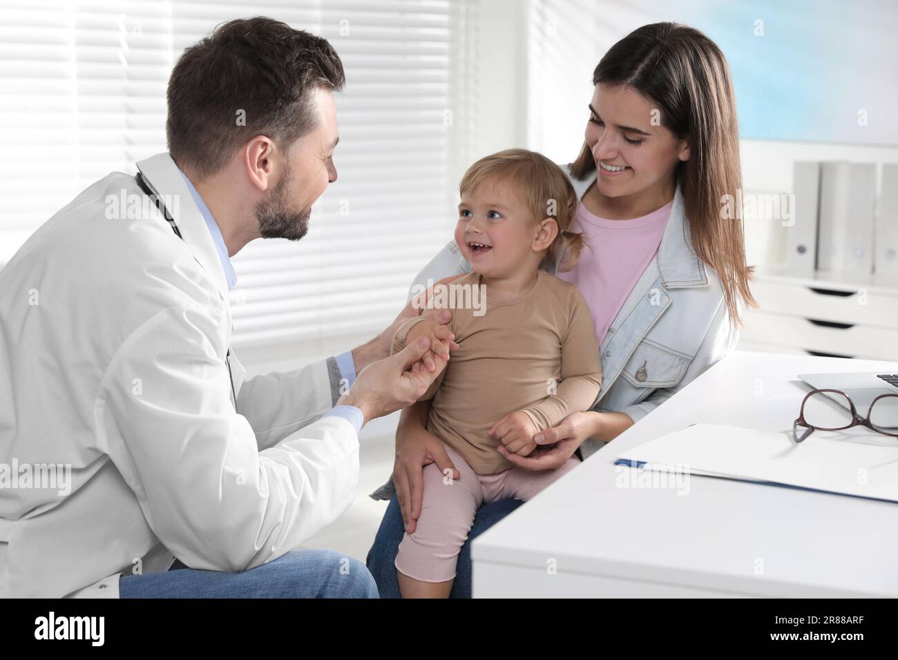 Mother and her cute baby having appointment with pediatrician in clinic ...