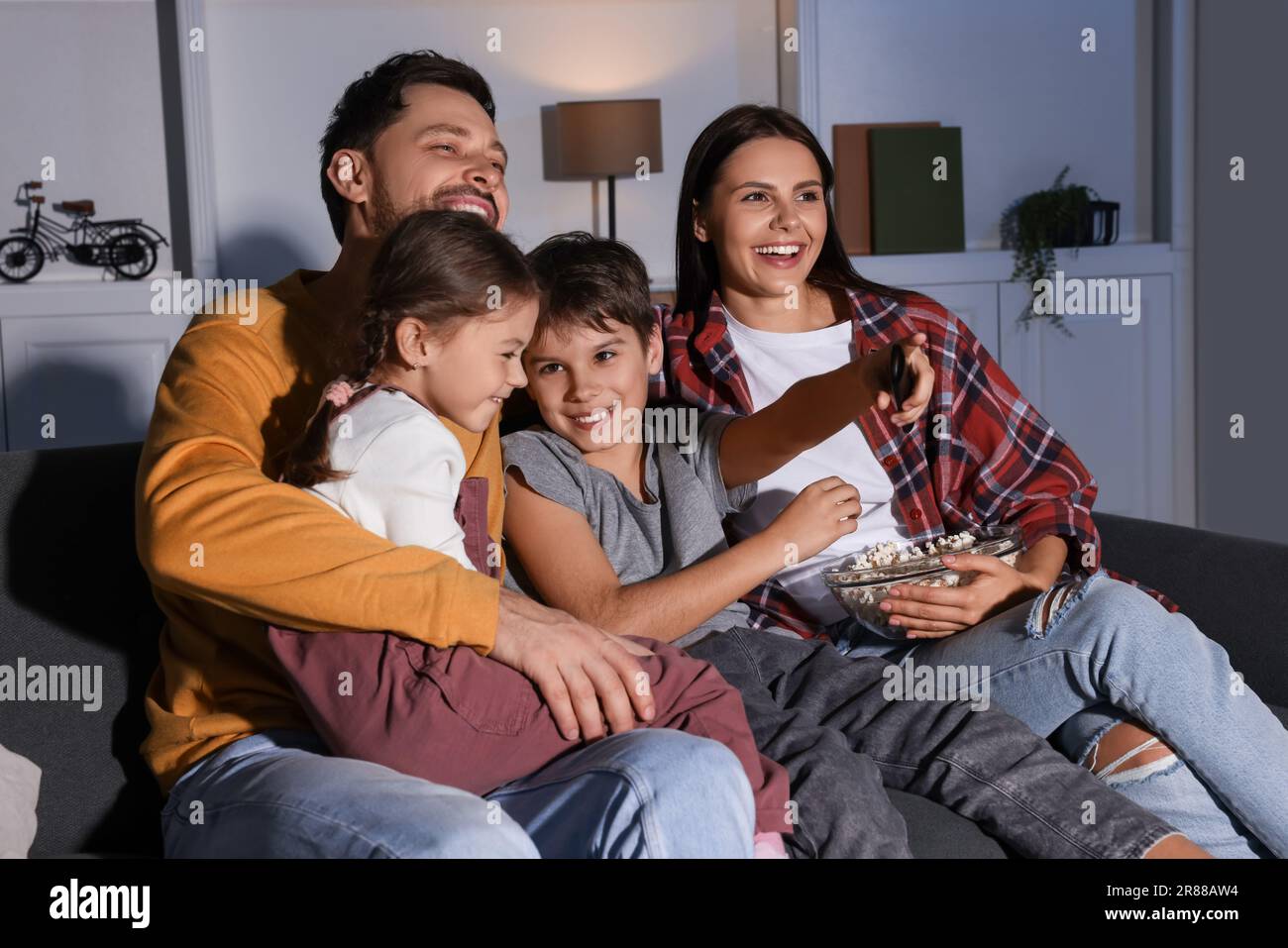 Happy family watching TV at home in evening Stock Photo - Alamy