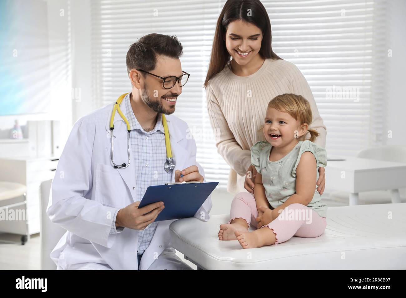 Mother and her cute baby having appointment with pediatrician in clinic ...