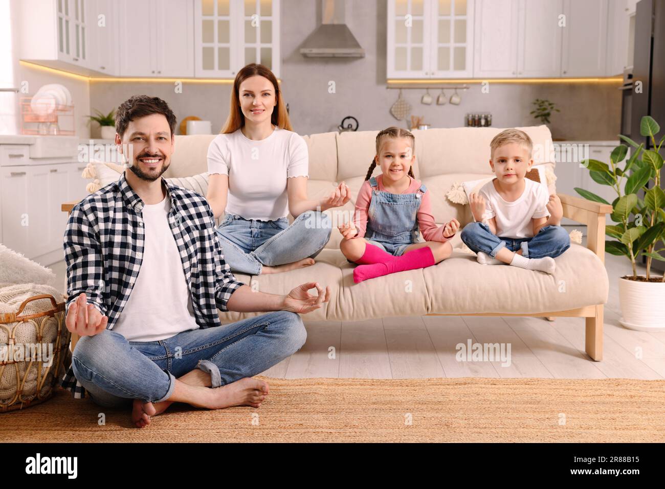 Happy family meditating together at home. Harmony and zen Stock Photo ...