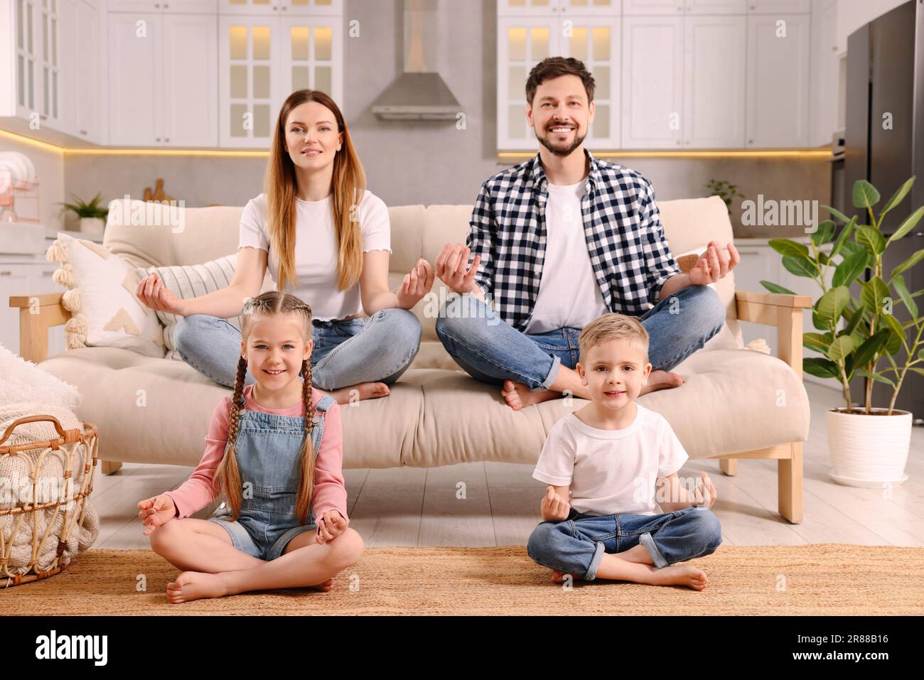 Happy family meditating together at home. Harmony and zen Stock Photo ...
