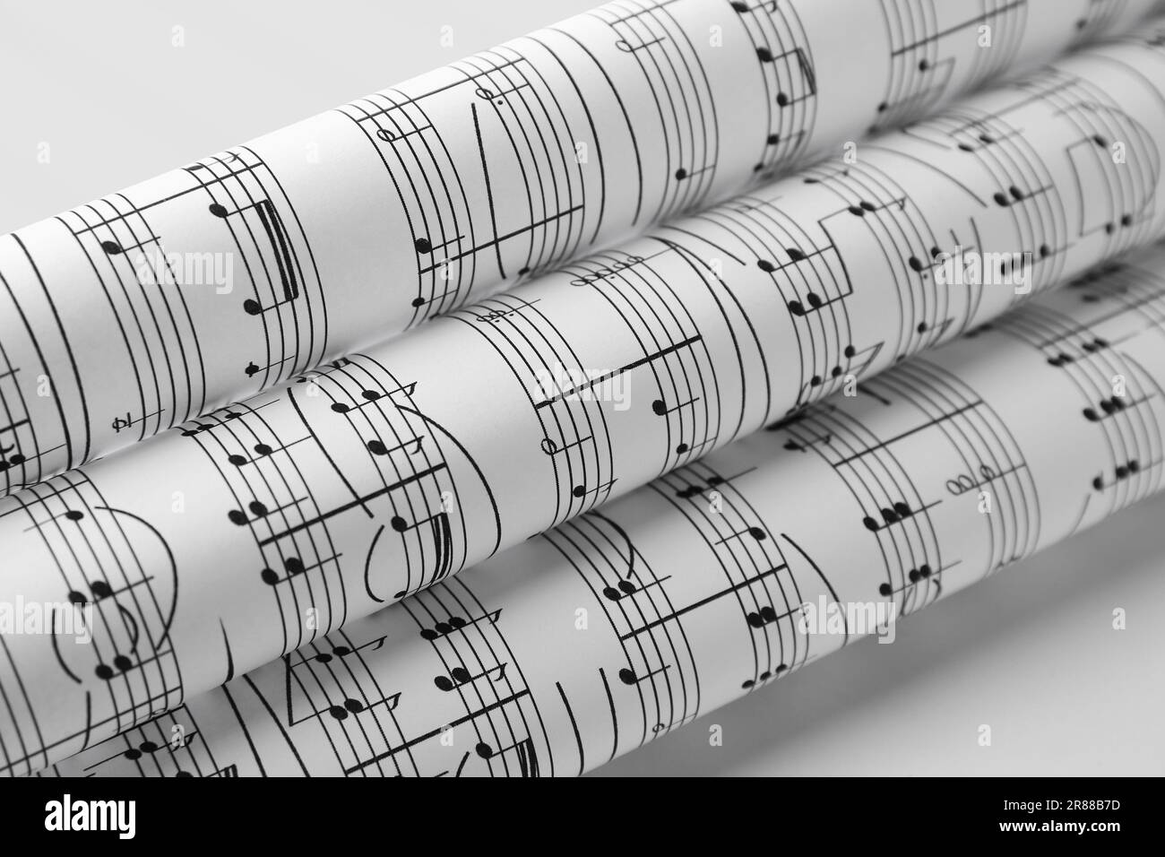 Rolled sheets with music notes on white background, closeup Stock Photo ...