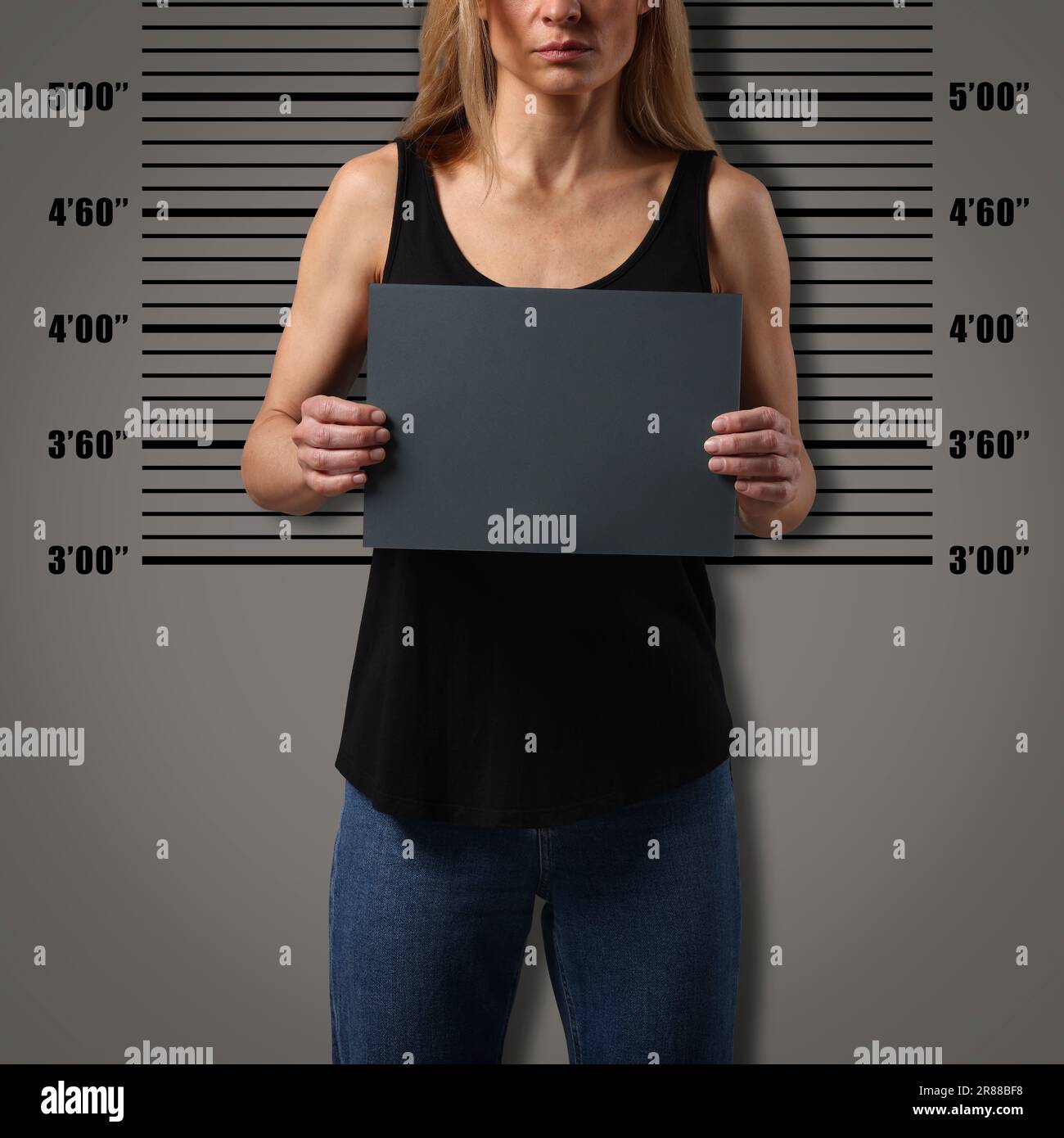 Criminal mugshot. Arrested woman with blank card against height chart ...