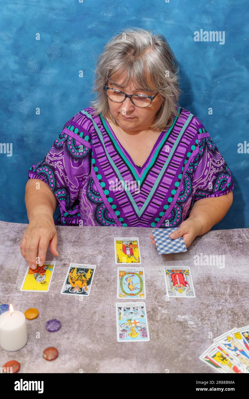 Older white haired woman pythoness casting tarot cards Stock Photo - Alamy