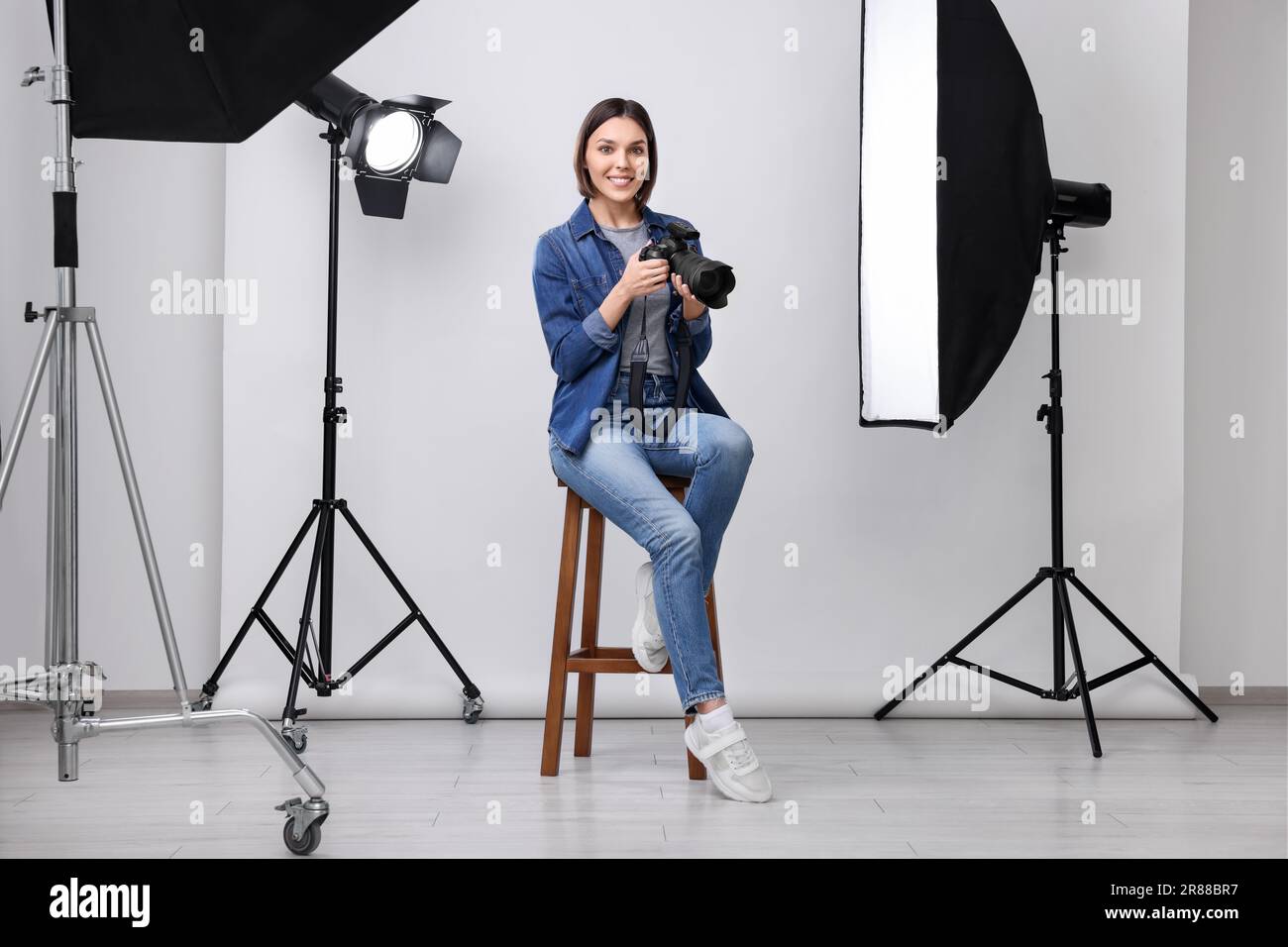 Professional photographer with camera in modern photo studio Stock ...